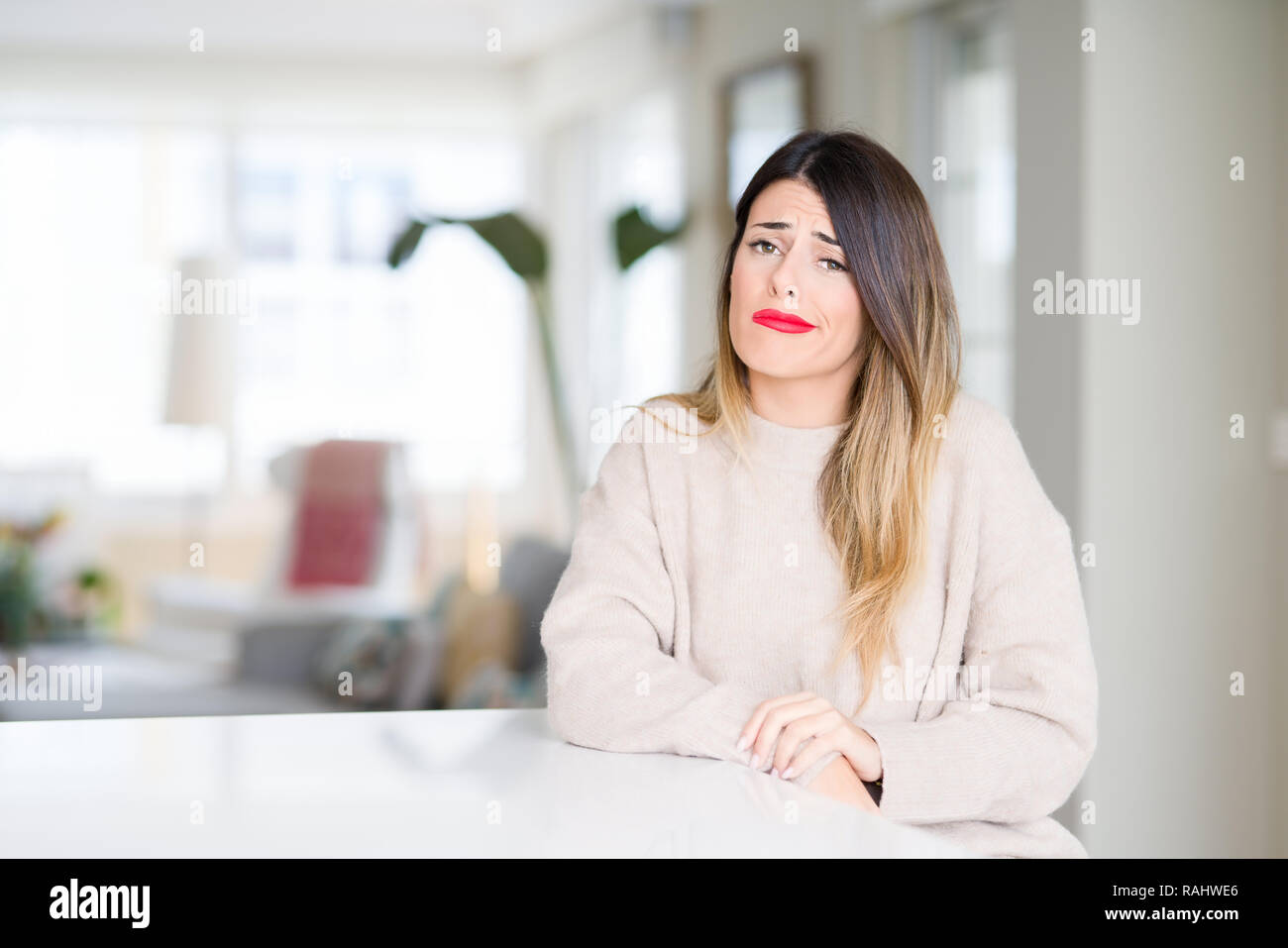 Young beautiful woman wearing winter sweater at home depressed and ...
