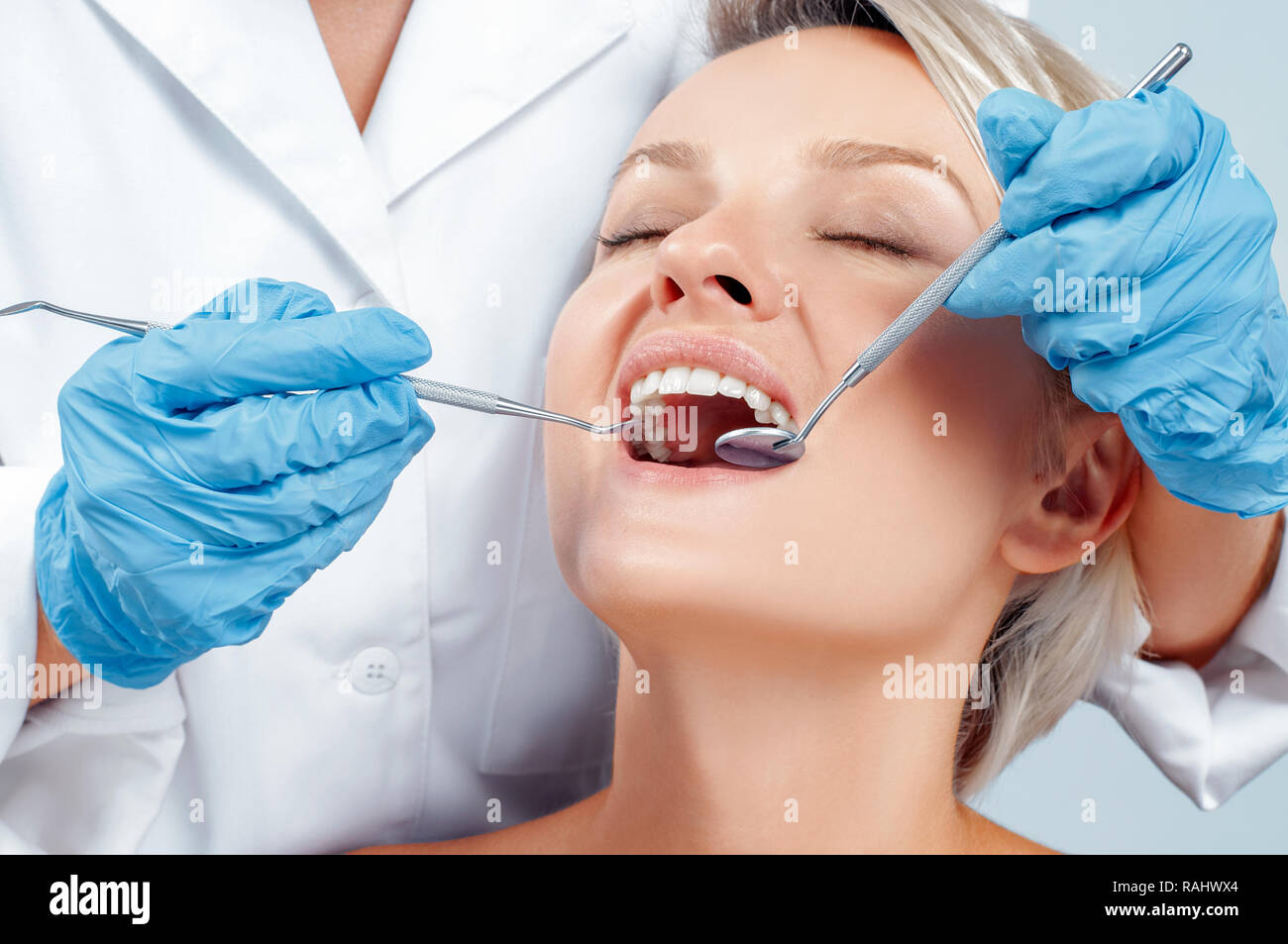 Dentist examining patient teeth in the dentis. Doctor doing dental treatment woman's teeth Stock ...
