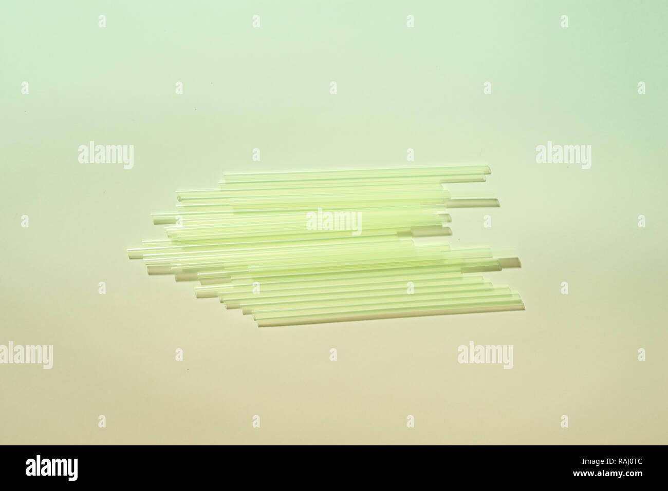 Green plastic straws on light background. Event and party supplies ...