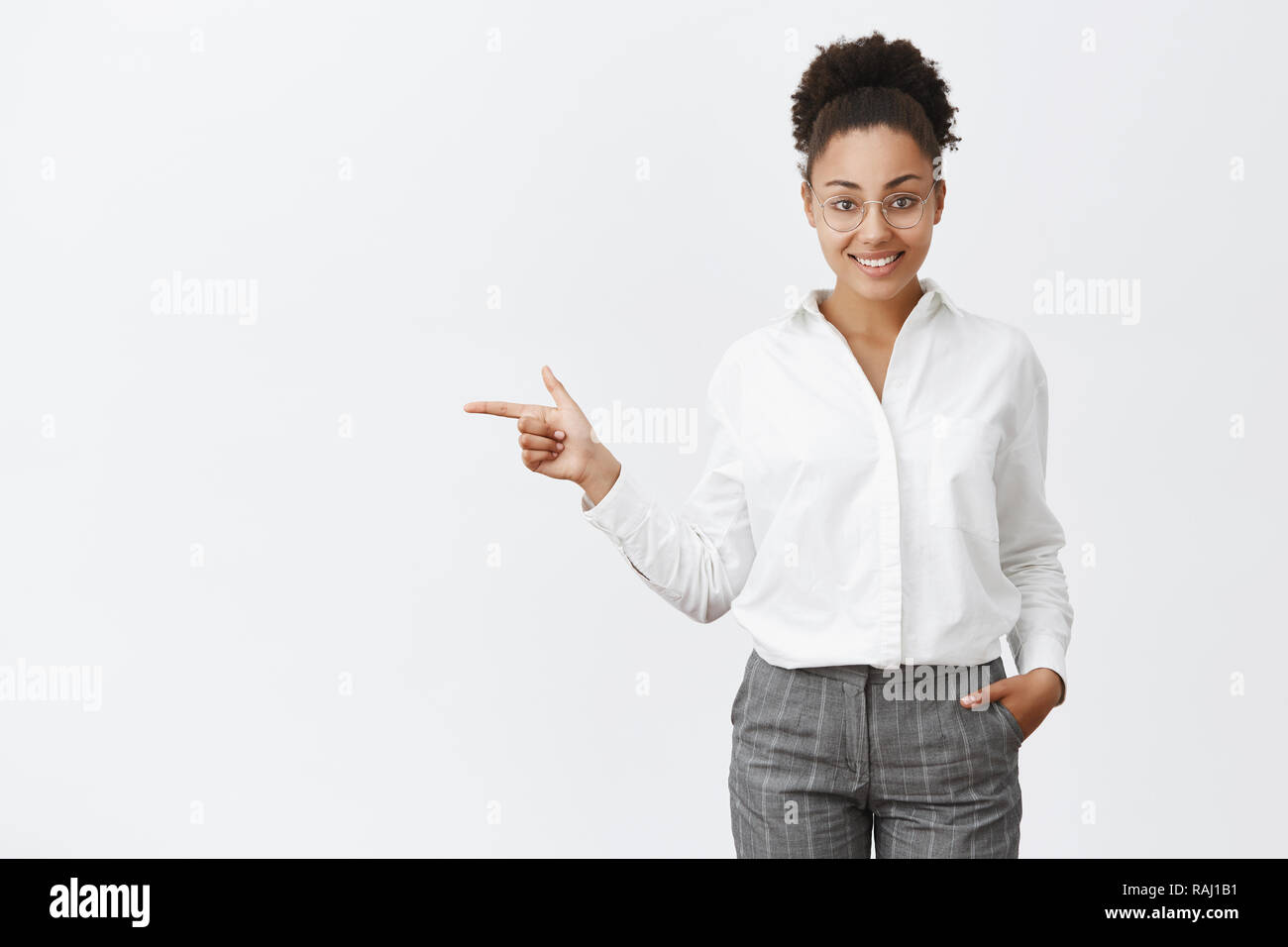 Charming and friendly office worker showing way out to customer ...