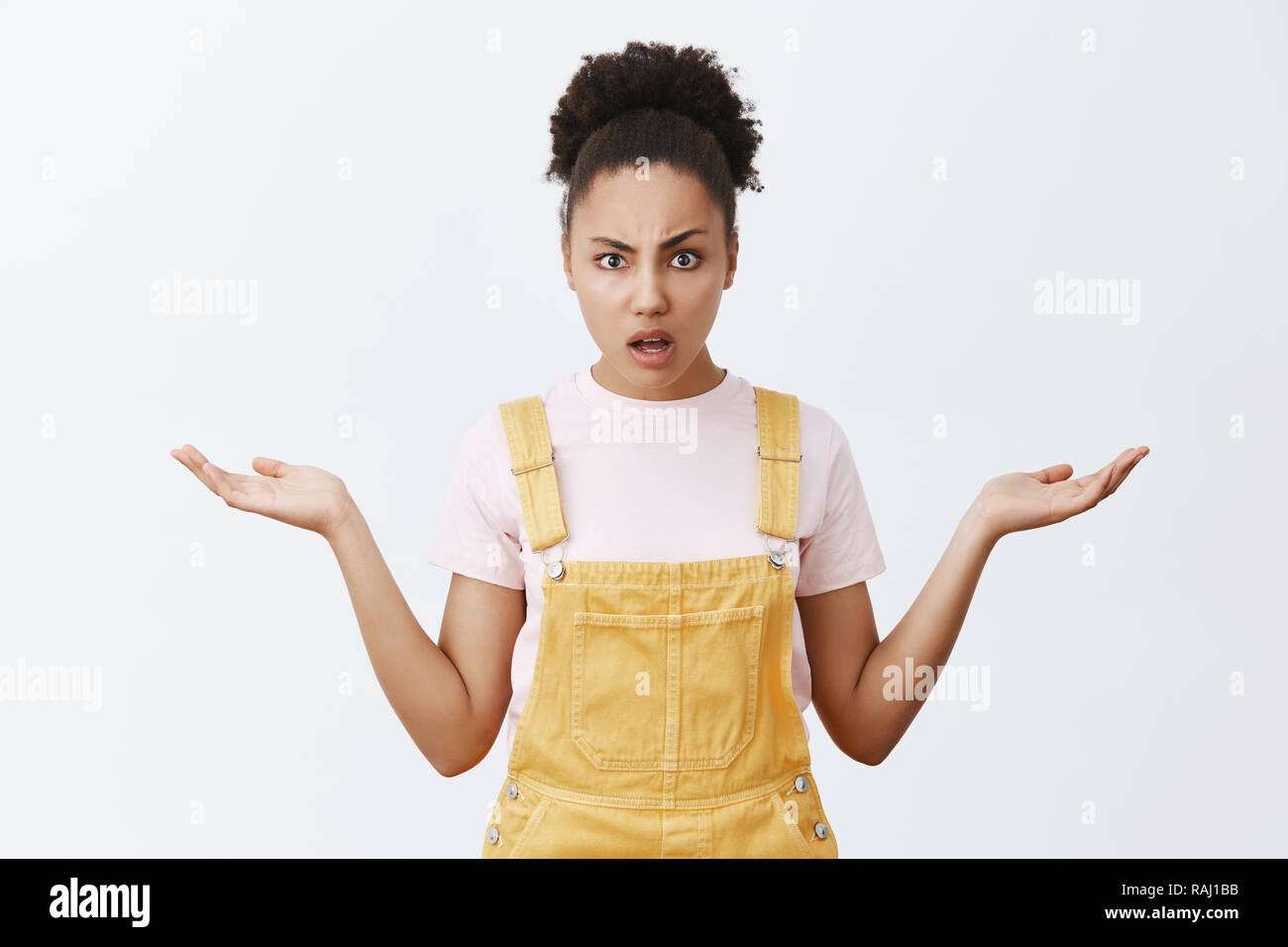 Portrait of intense confused dark-skinned girl with curly hair in ...