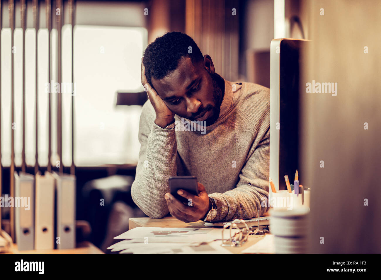 Attentive young man staring at screen of his gadget Stock Photo - Alamy