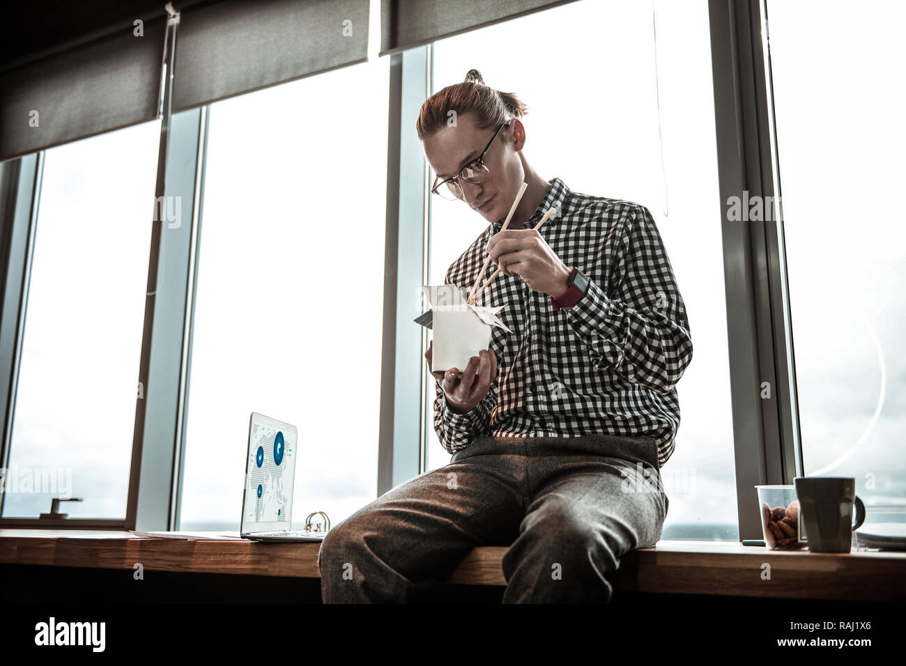Attentive man looking downwards at paper box Stock Photo - Alamy