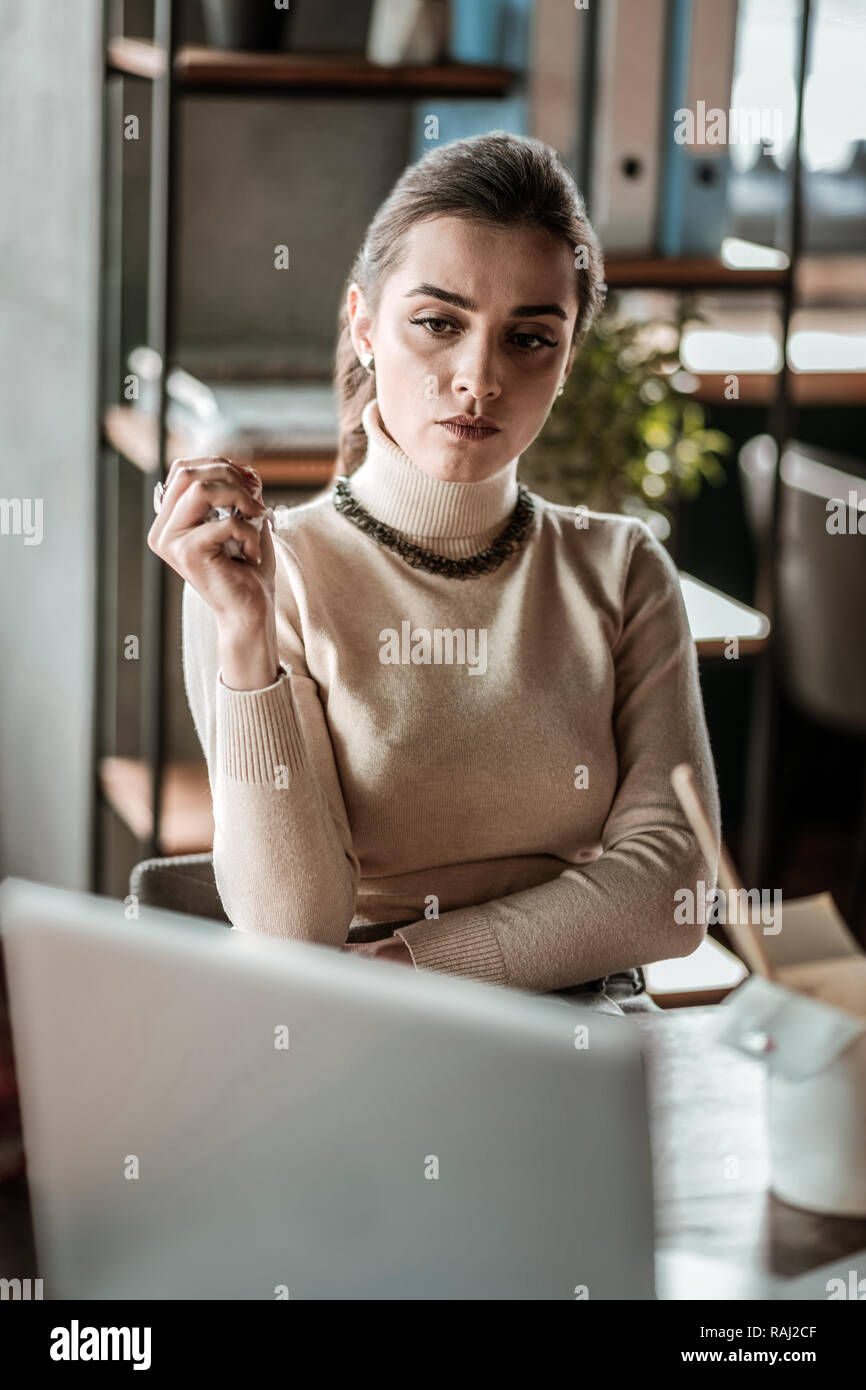 Emotional brunette girl staring at screen of computer Stock Photo - Alamy
