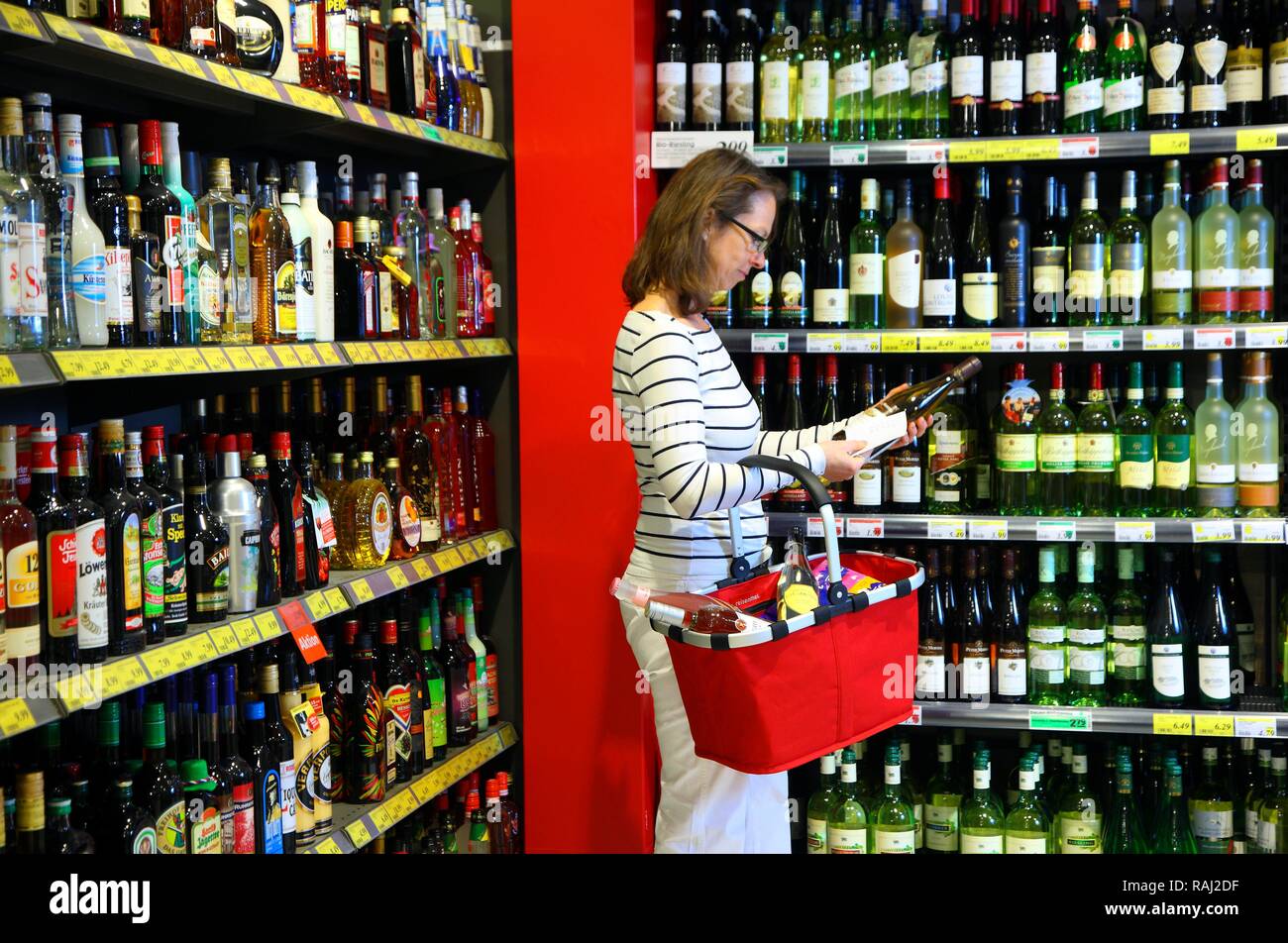 Woman shopping in the beverage section, sparkling wine, champagne ...