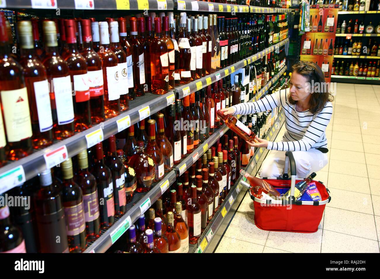Woman shopping in the beverage section, sparkling wine, champagne ...