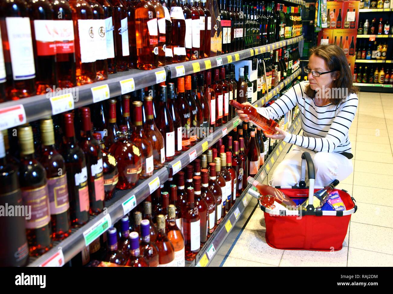 Woman shopping in the beverage section, sparkling wine, champagne ...