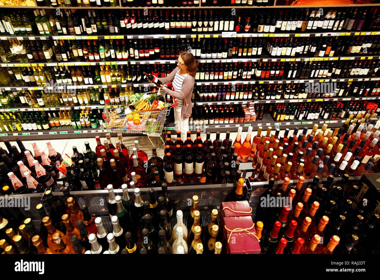 Woman shopping in the beverage section, sparkling wine, champagne ...