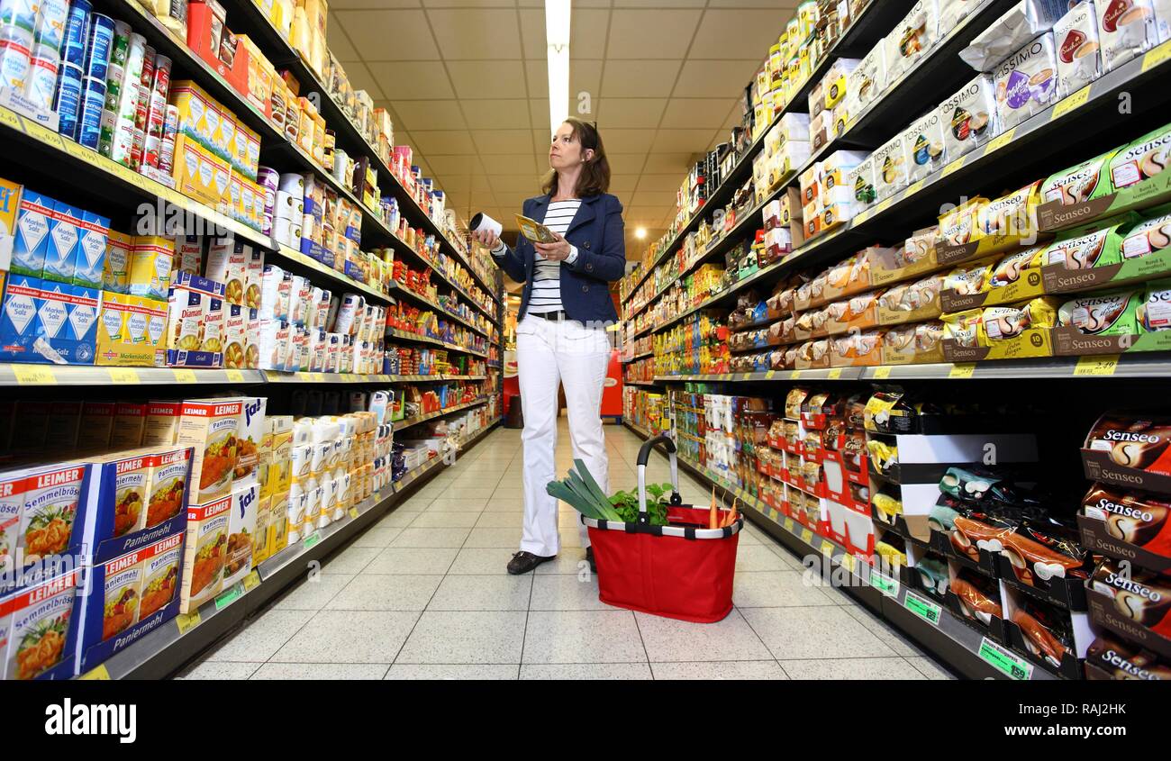 Woman purchasing flour and baking ingredients in a self-service grocery ...