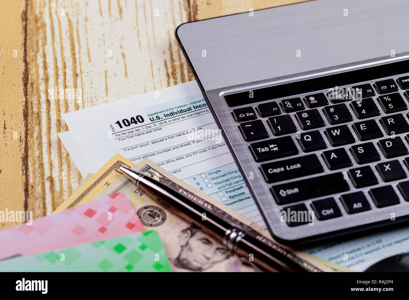 US 1040 tax form with pen and laptop keyboard, american dollars Stock ...
