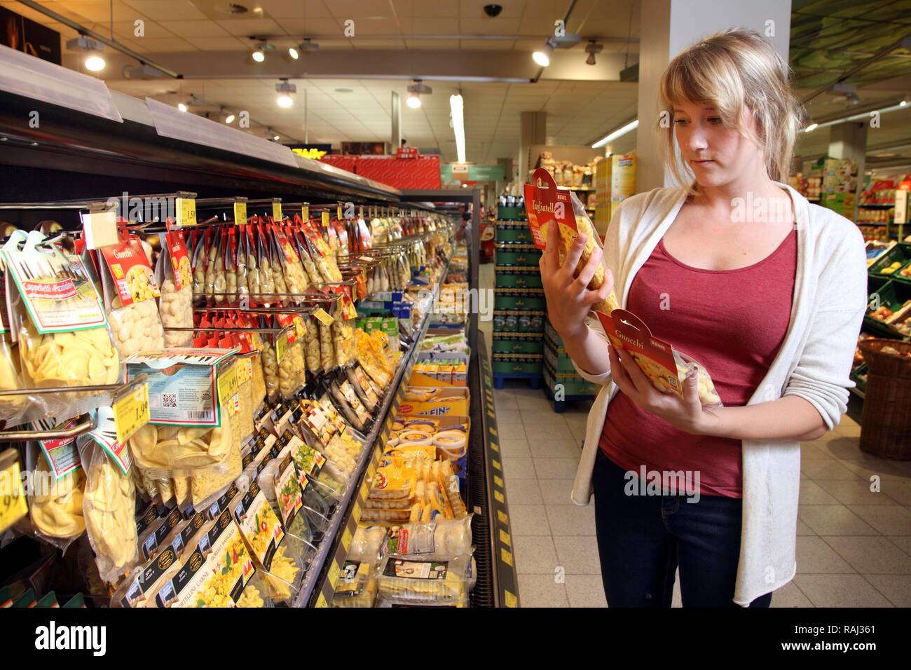 Customer, woman standing in front of the refrigerated counter with ...