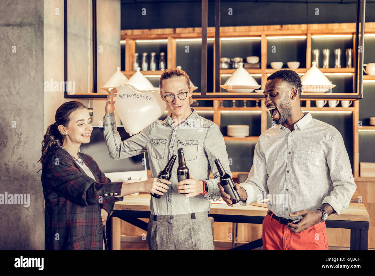 Pleased tall man having party at new workplace Stock Photo - Alamy