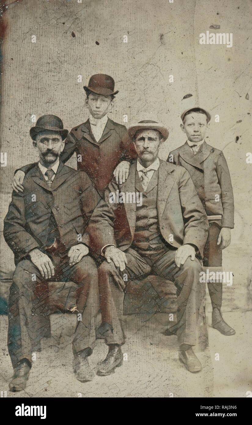 Portrait of two men and two boys, standing and sitting in front of a ...
