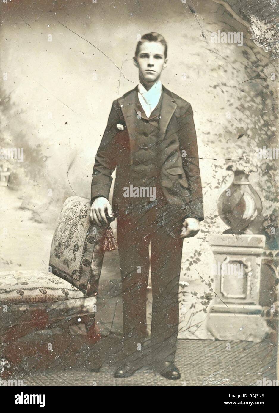 Portrait of a young man standing in front of a painted backdrop ...