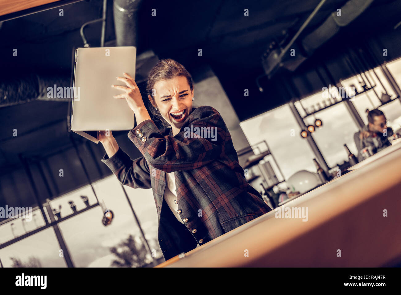 Angry office worker going to throw her laptop Stock Photo - Alamy