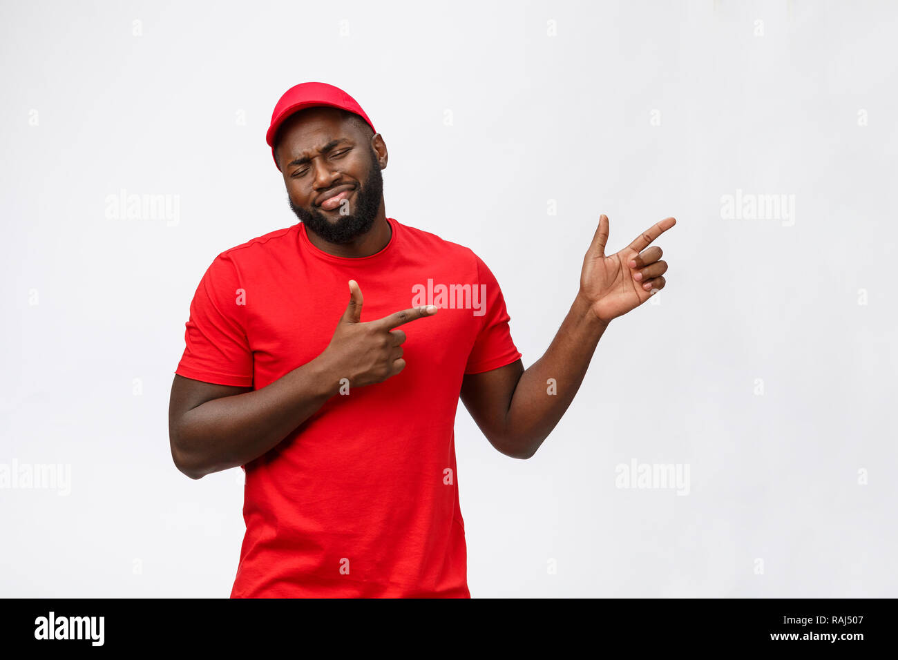 Portrait of handsome african american delivery man annoying pointing ...