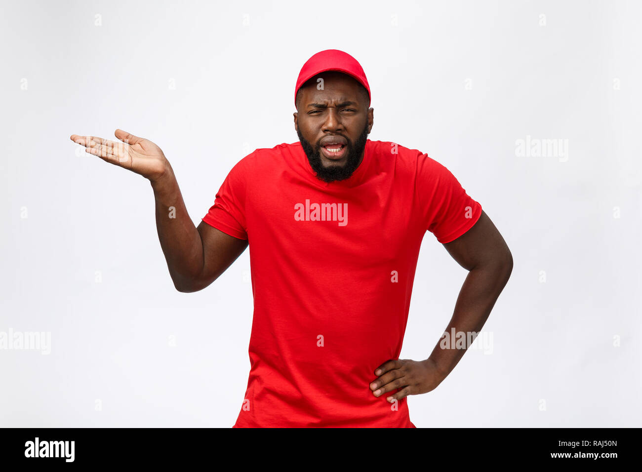 Portrait of handsome african american delivery man annoying pointing ...