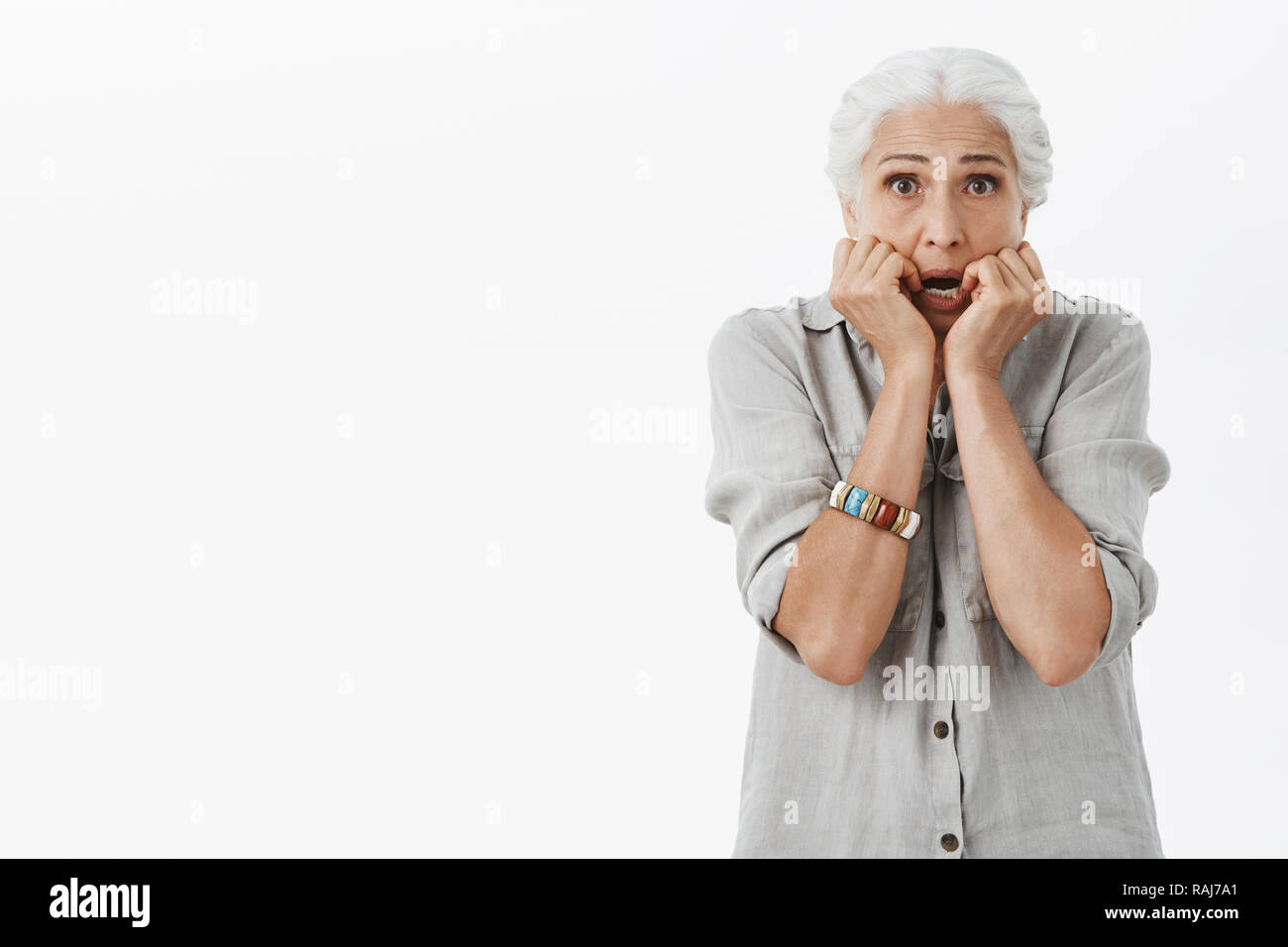 Waist-up shot of scared and concerned old lonely lady feeling unsafe ...