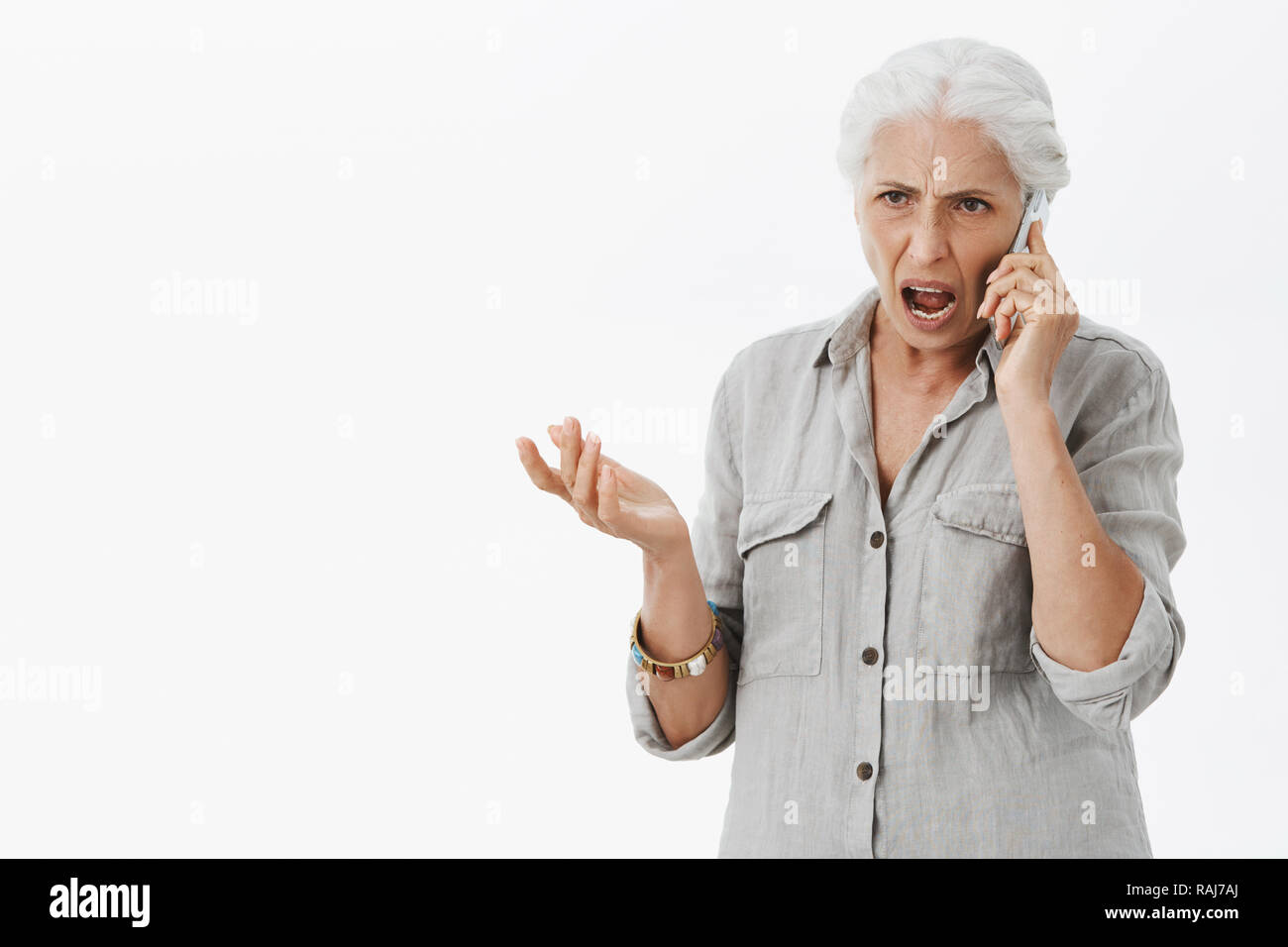Waist-up shot of pissed and angry senior lady with white hair arguing ...