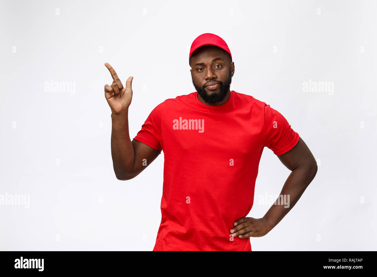 Portrait of handsome african american delivery man annoying pointing ...