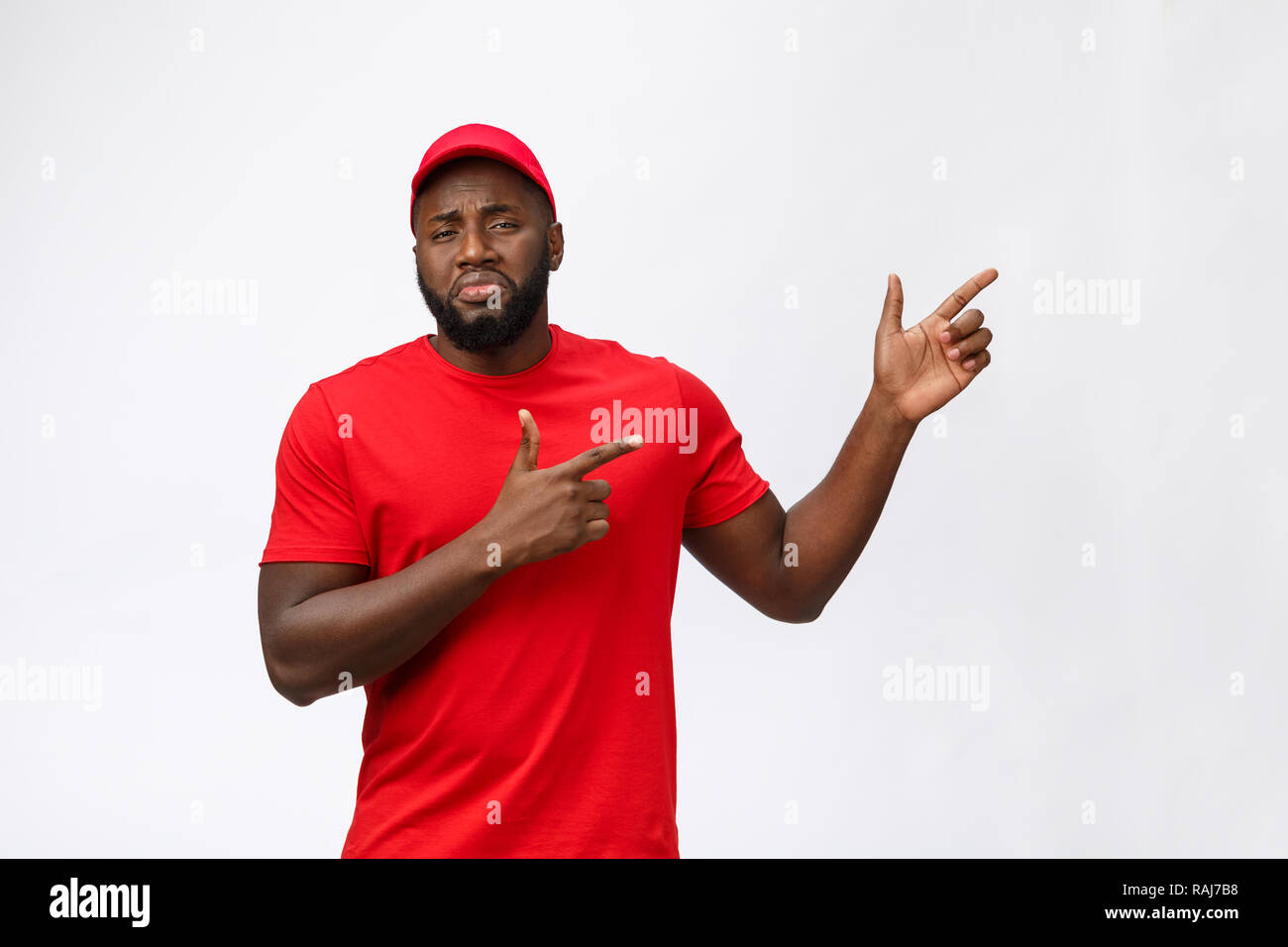 Portrait of handsome african american delivery man annoying pointing ...