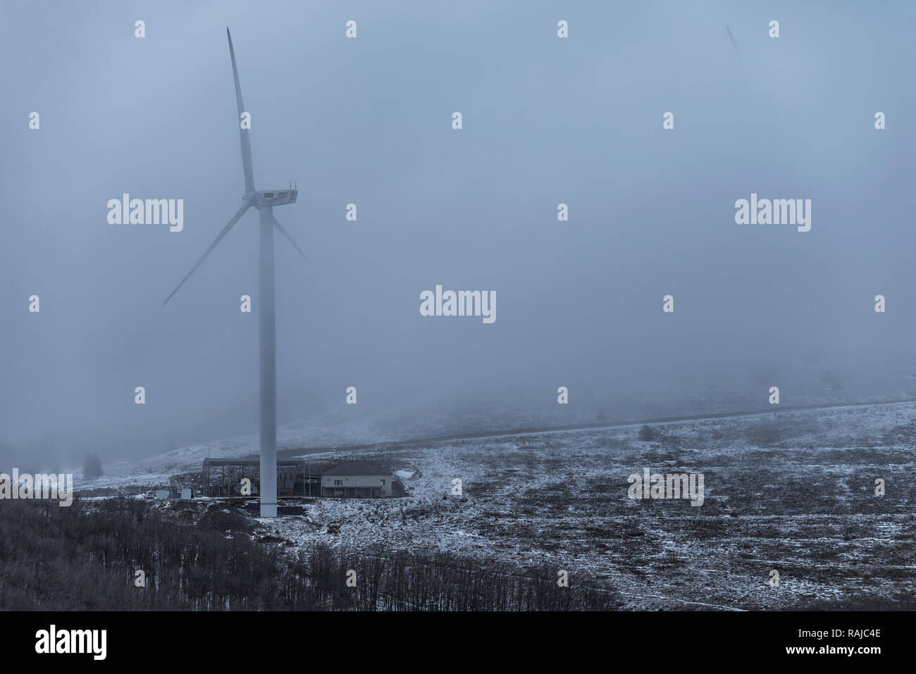 Winter landscape with wind turbines and clouds on a snow covered ...