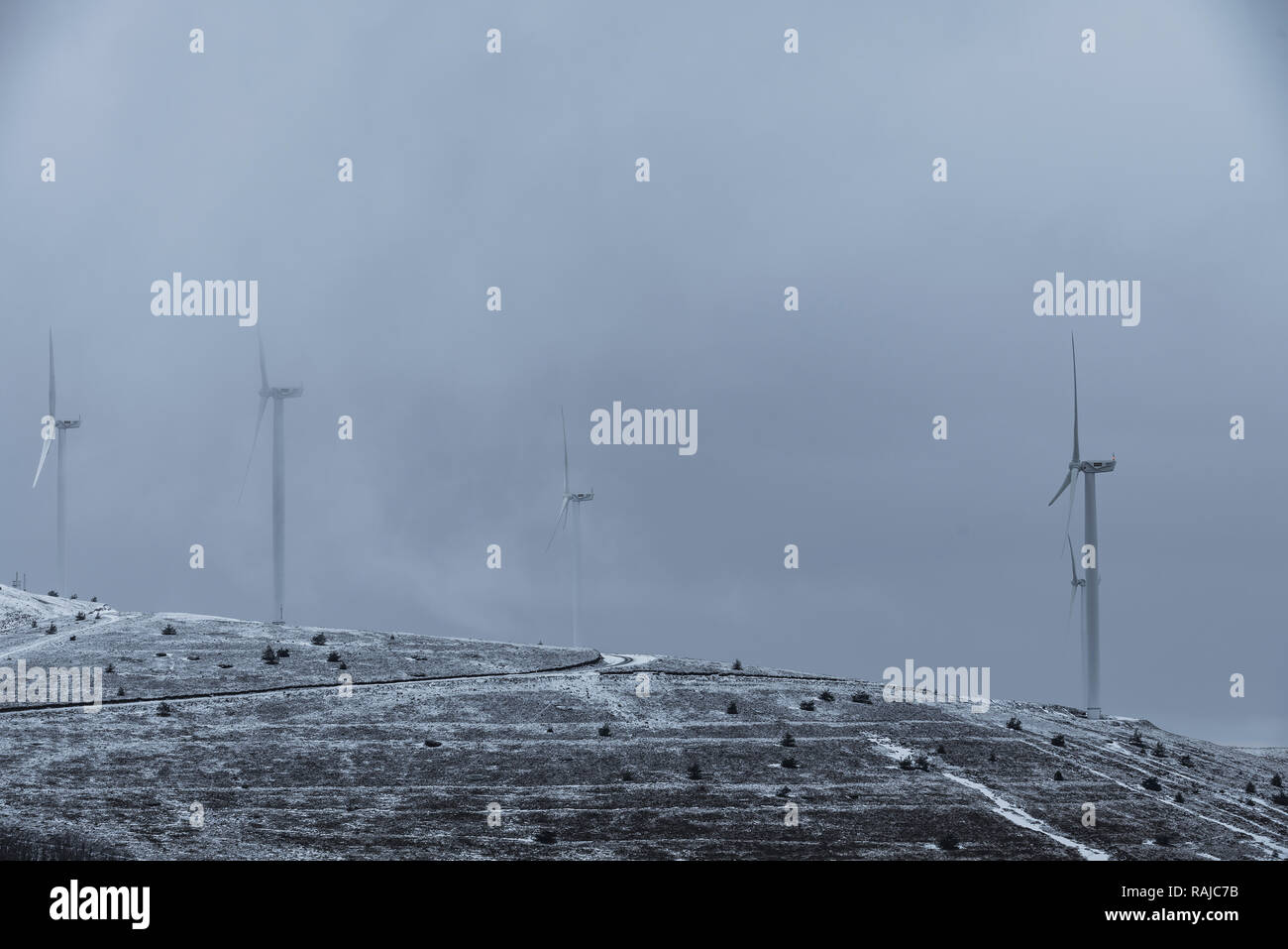 Winter landscape with wind turbines and clouds on a snow covered ...