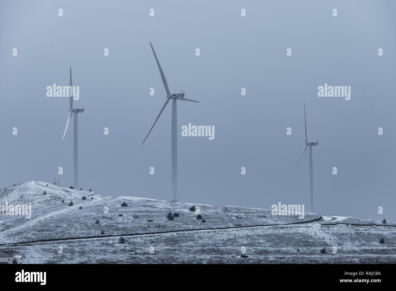 Winter landscape with wind turbines and clouds on a snow covered ...