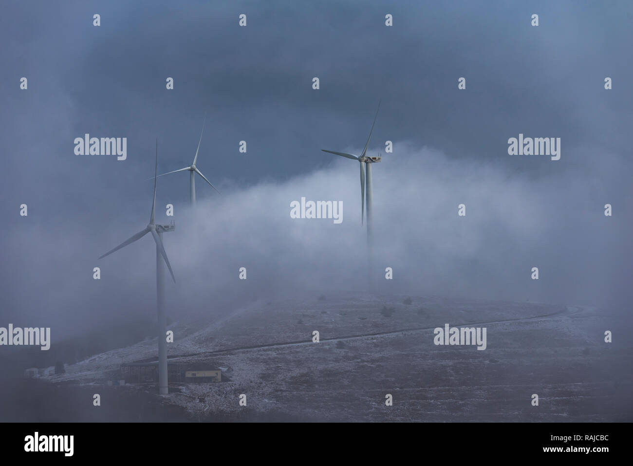 Winter landscape with wind turbines and clouds on a snow covered ...