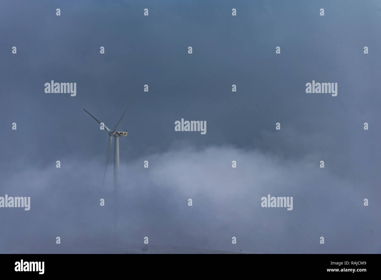 Winter landscape with wind turbines and clouds on a snow covered ...