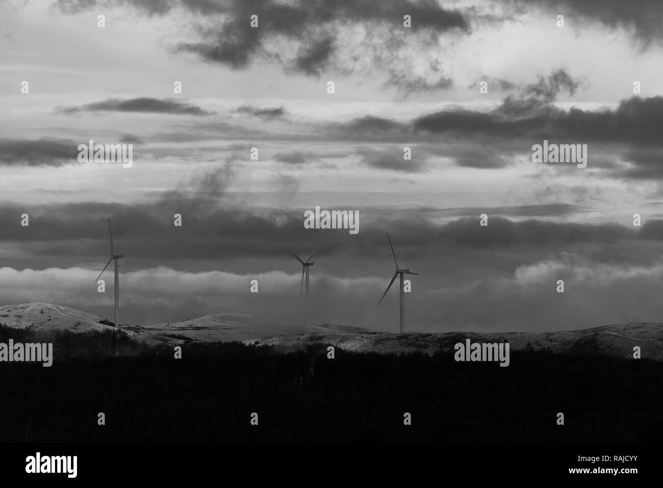 Winter landscape with wind turbines and clouds on a snow covered ...