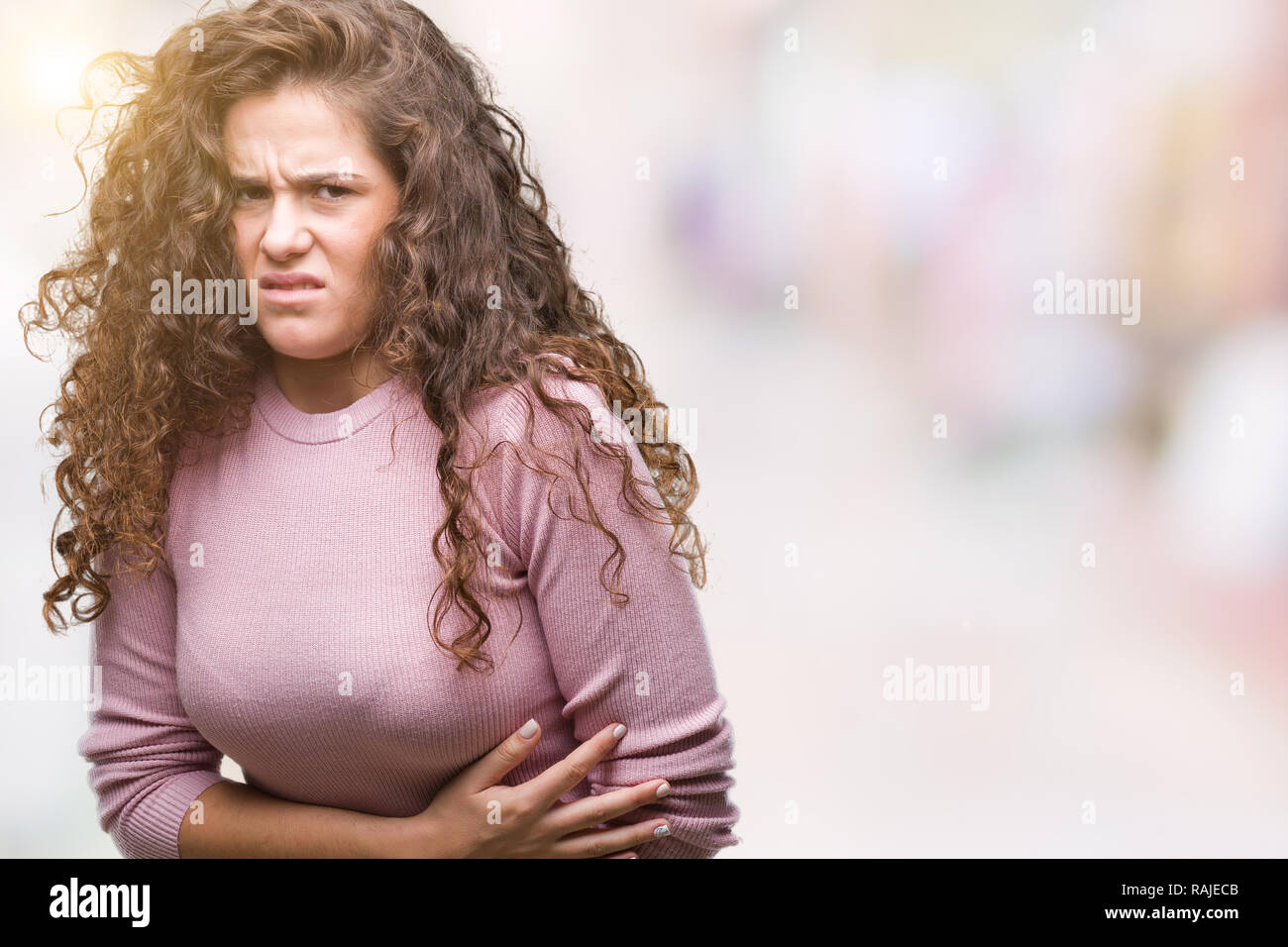Beautiful brunette curly hair young girl wearing pink sweater over ...