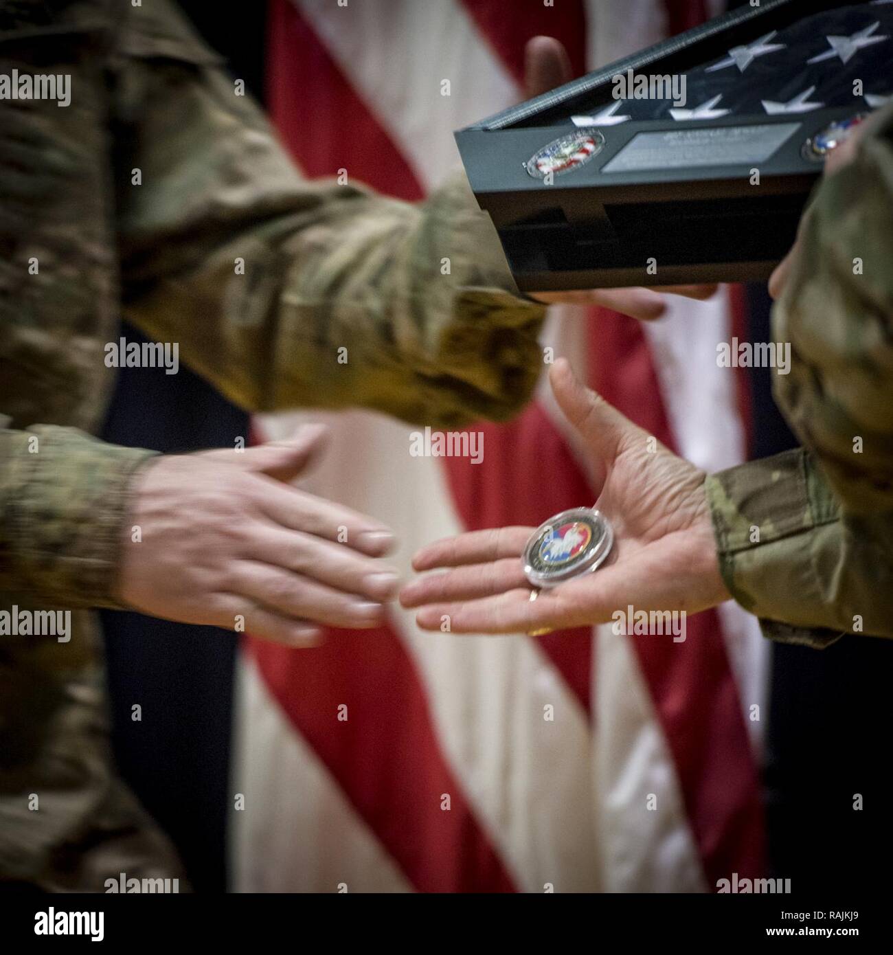 U.S. Army Reserve Maj. Gen. Peter A. Bosse hands a commemorative coin ...