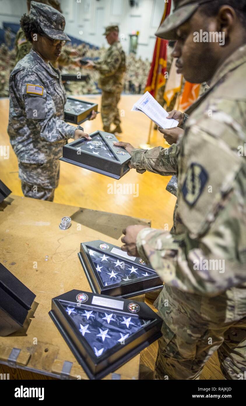 Soldiers with the 335th Signal Command (Theater) pass commorative flags ...
