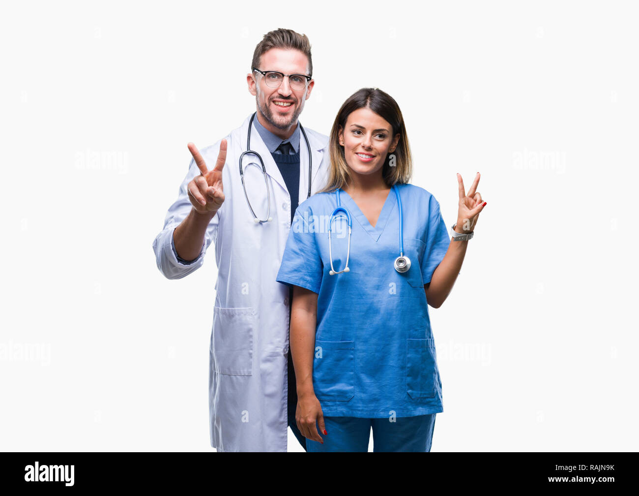 Young couple of doctor and surgeon over isolated background smiling ...