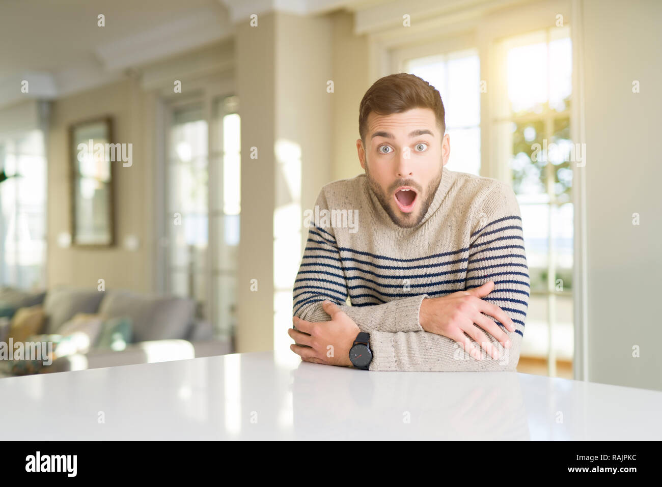 Young handsome man at home afraid and shocked with surprise expression ...