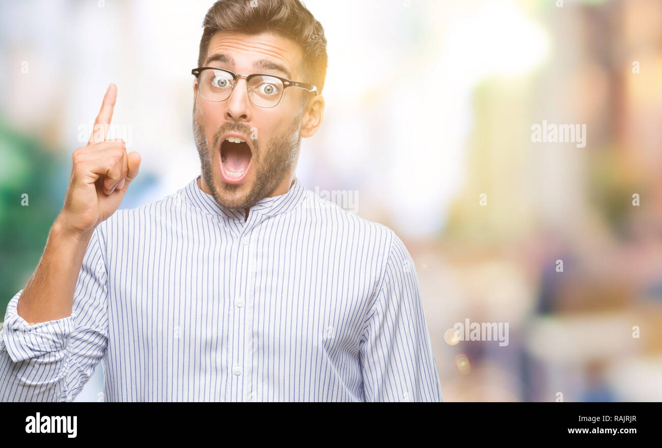Young handsome man over isolated background pointing finger up with ...