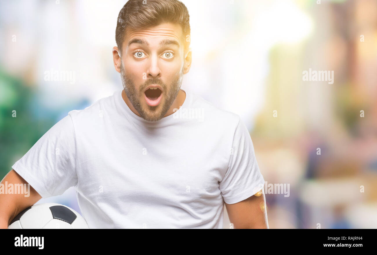 Young handsome man holding soccer football ball over isolated ...