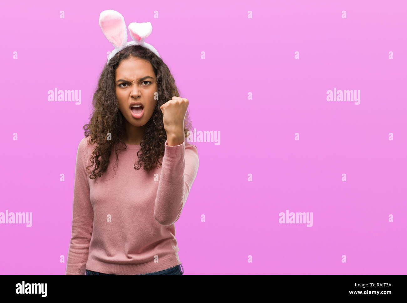 Young hispanic woman wearing easter bunny ears annoyed and frustrated ...