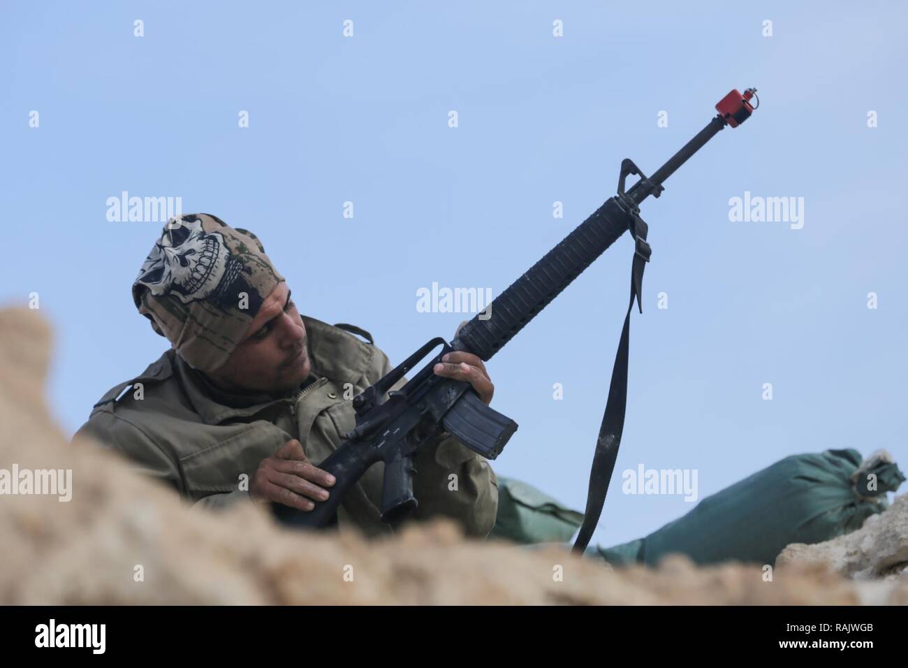 An Iraqi security forces soldier checks his M16 rifle during checkpoint ...