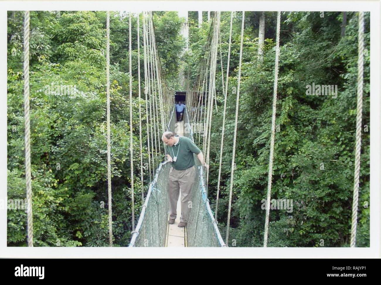 MEN WALKING ACROSS SMALL ROPE BRIDGE Stock Photo - Alamy