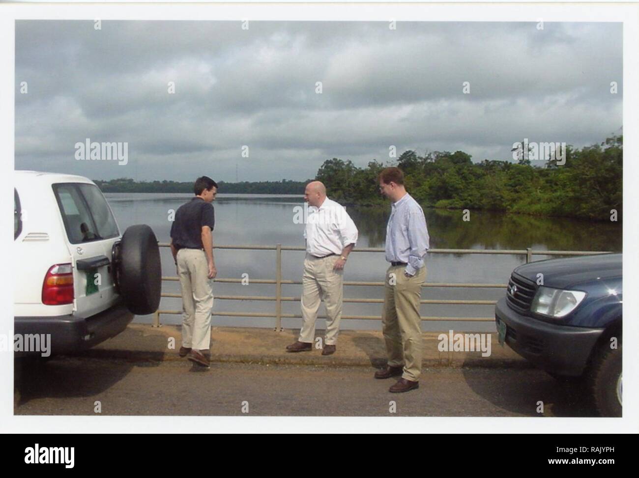 THREE MEN LOOKING OVER RAILING Stock Photo - Alamy