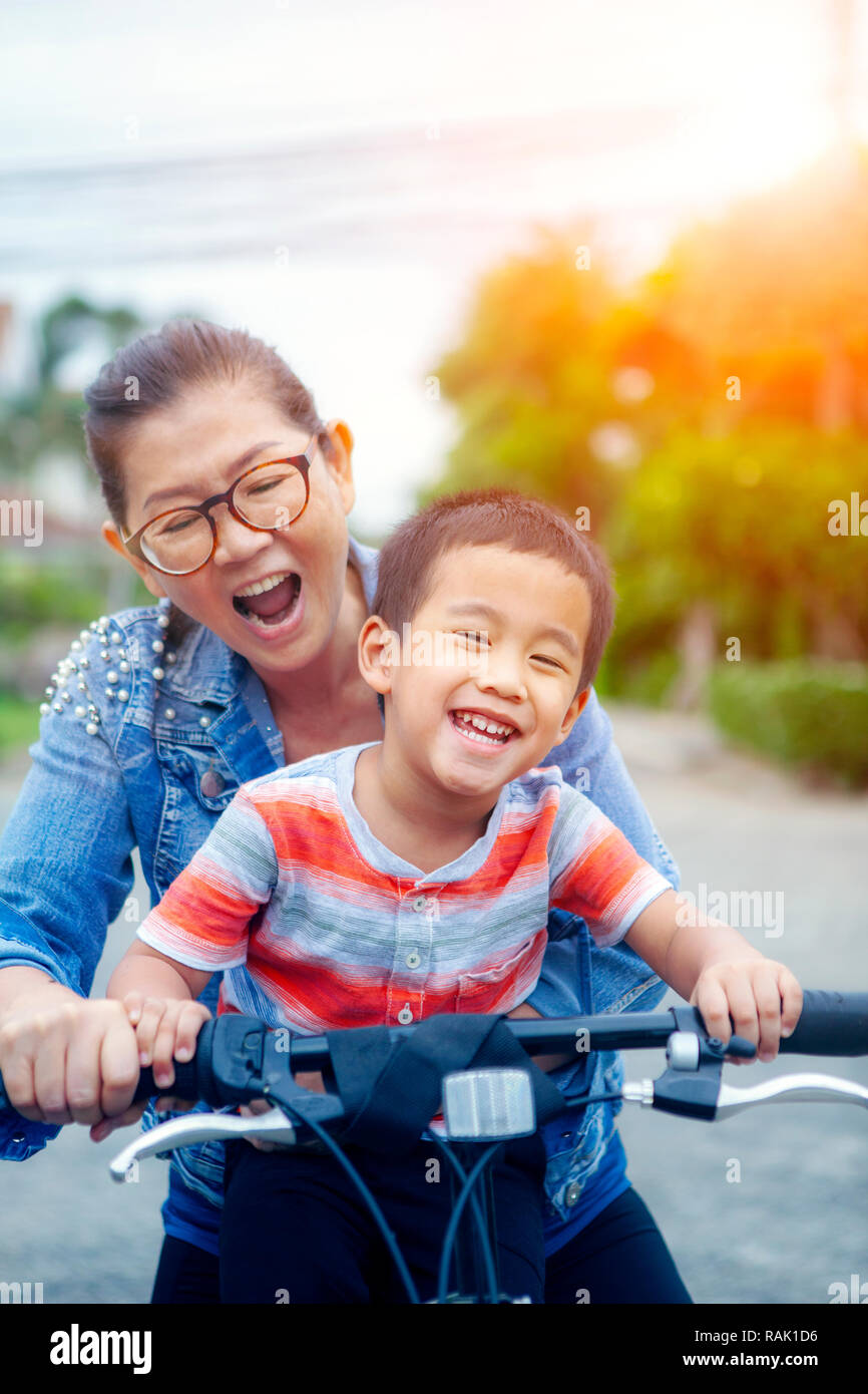 portrait of asian children riding bicycle with mother smiling face ...