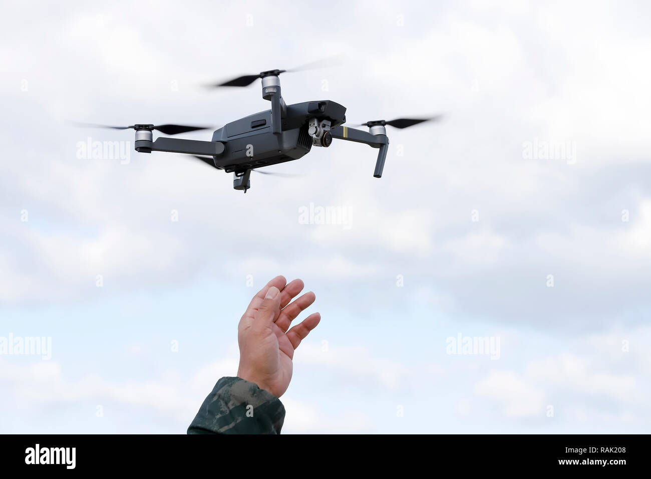 Hand catching drone aircraft in sky background, camera operator concept ...