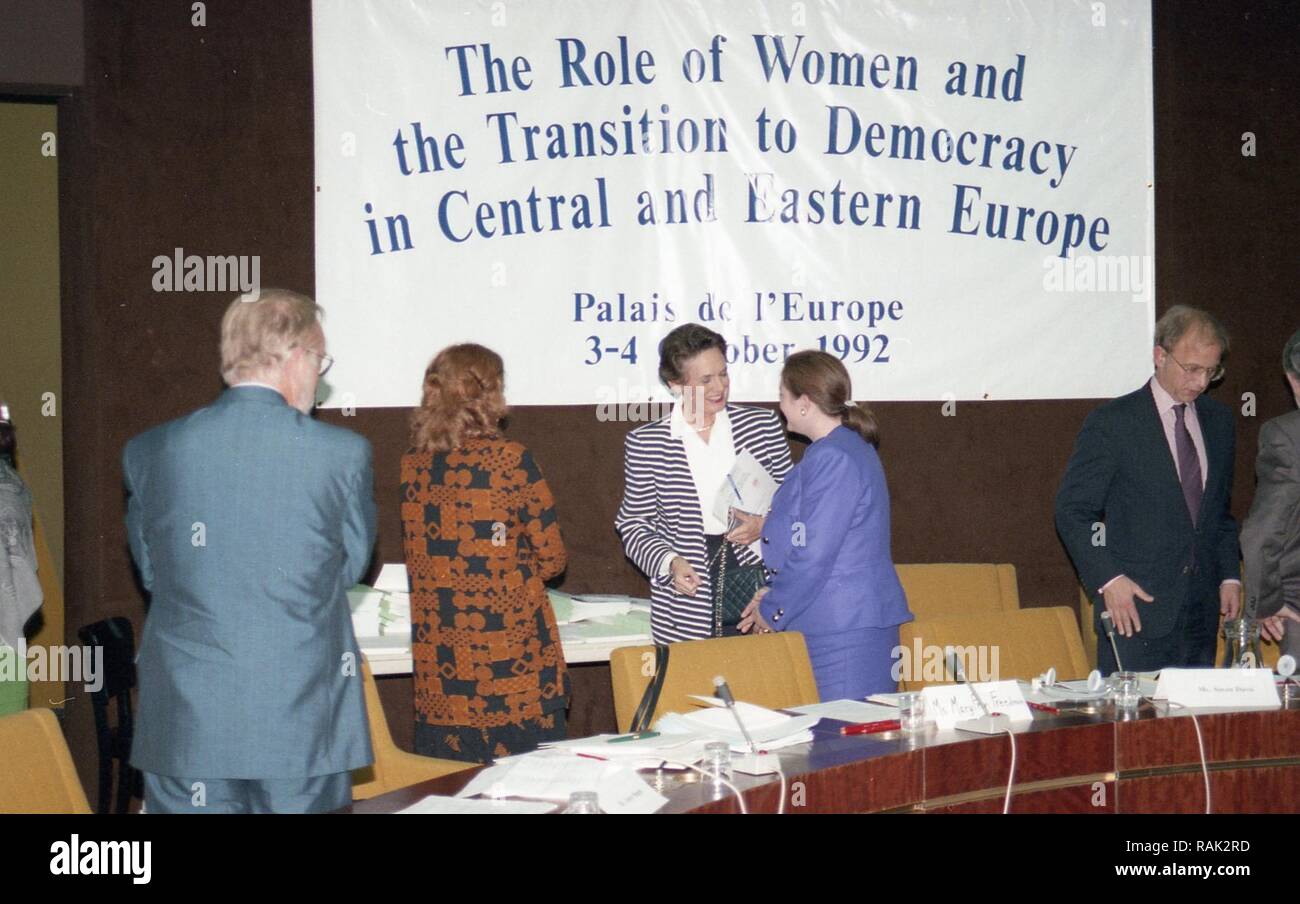 TWO WOMEN ARE HAVING A CONVERSATION WITH OTHER MEN AND WOMEN AROUND ...