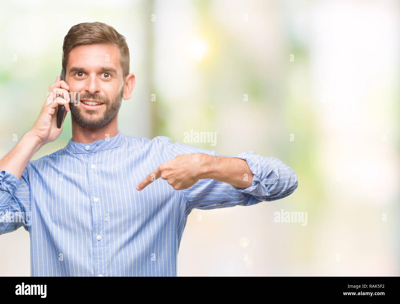 Young handsome man speaking on the phone over isolated background with ...