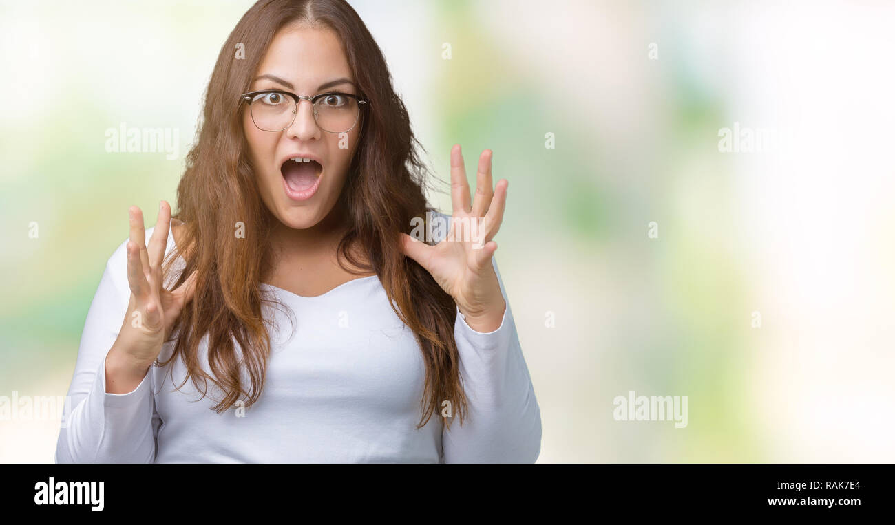 Beautiful plus size young woman over isolated background crazy and mad ...
