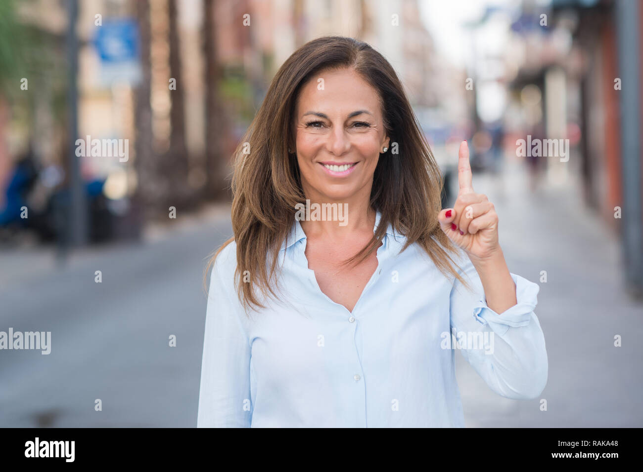 Beautiful middle age hispanic woman at the city street on a sunny day ...