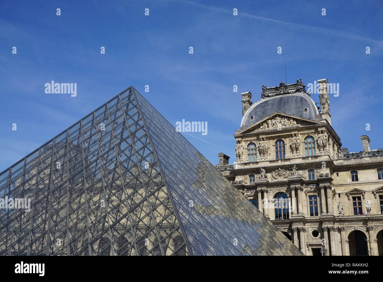 The famous glass pyramid at the Louvre in Paris on a beautiful blue ...