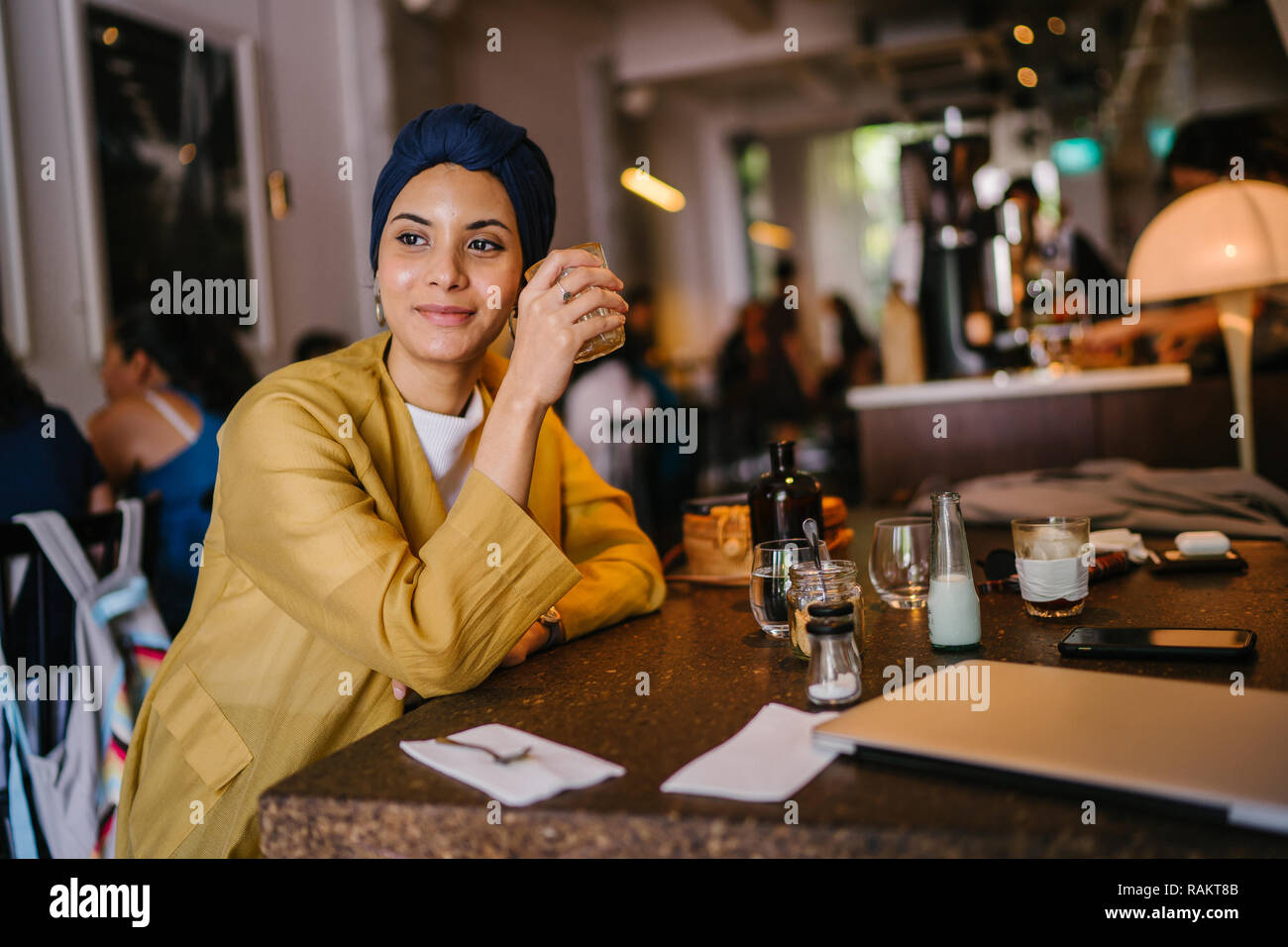 A young and beautiful Muslim woman of Middle Eastern ethnicity sips and ...